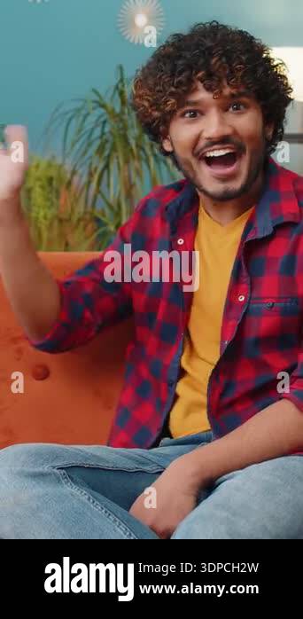 Hello. Indian handsome man smiling friendly at camera and waving hands ...