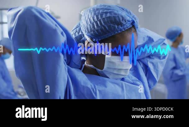 Surgeon lifting arms and tightening gown straps to prepare for surgery ...