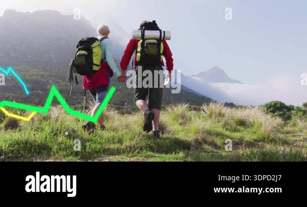 Mature hikers grasping hands and climbing slope while tracking progress ...