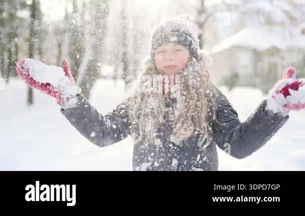 Slowmo of adorable young girl having fun in beautiful winter park ...