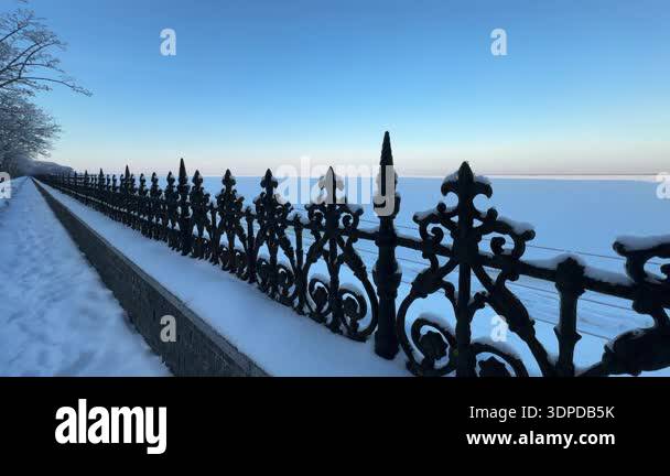 Winter waterfront promenade with decorative wrought iron fence covered ...