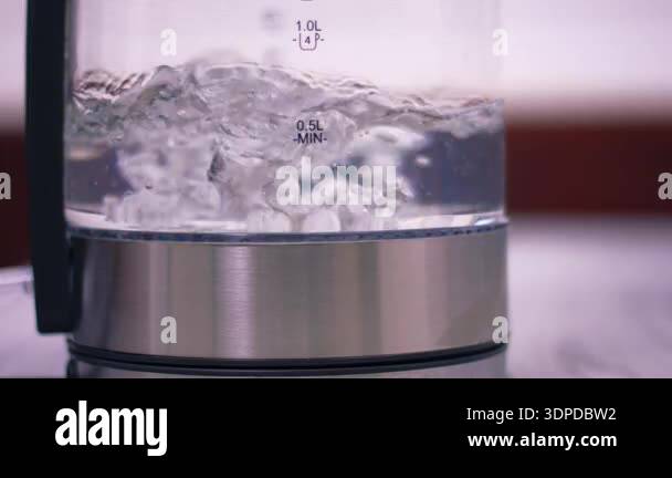 Hot water boiling in glass kettle close up 4k shot slow motion ...