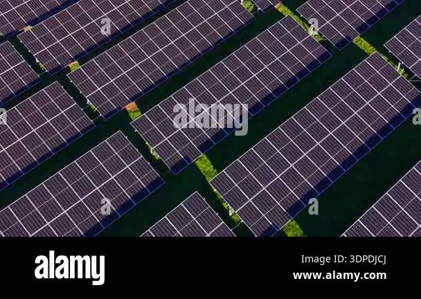 Rows of solar panels stretch across a green landscape, absorbing ...