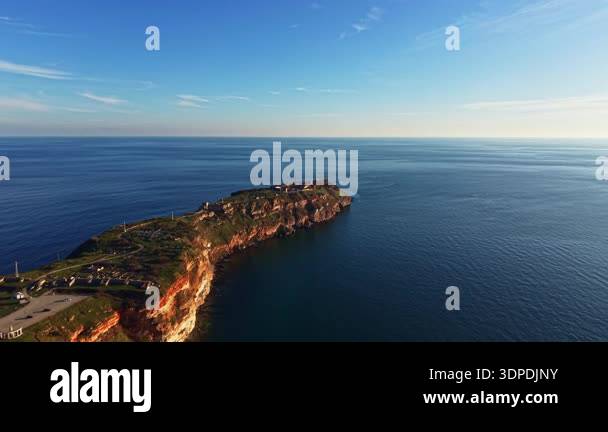A rocky coastline extends into the ocean, with cliffs rising above the ...