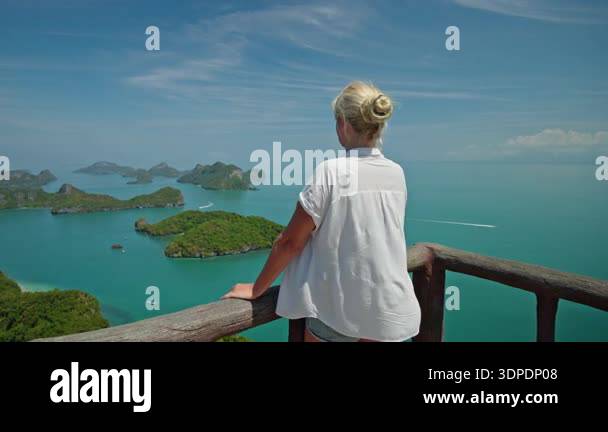 Middle-aged woman standing at a scenic viewpoint, looking over ...