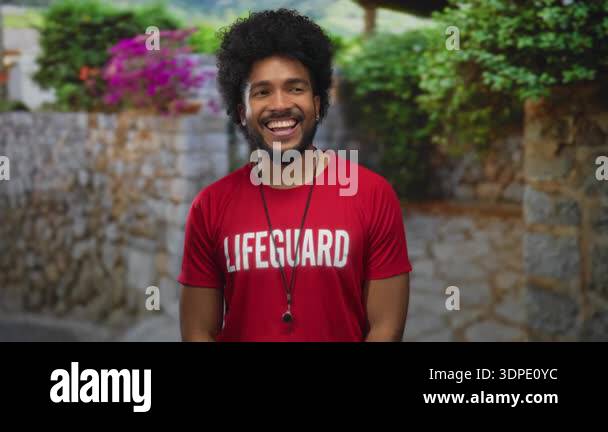 African american man lifeguard smiling outdoors wearing red shirt ...