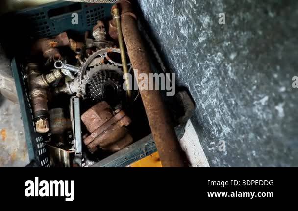 Old metal parts and tools are stored in a box inside a garage on a ...