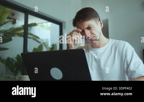 Millennial man frustrated and tired removes glasses shakes head and ...