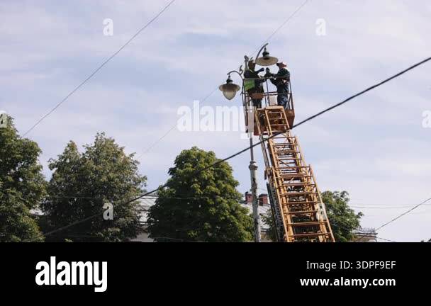Municipal worker, Street light, crane lifted. Street light repair work ...