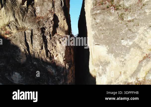Narrow Rock Canyon Under Clear Sky, Sunlit Vertical Cliffs Framing Deep ...