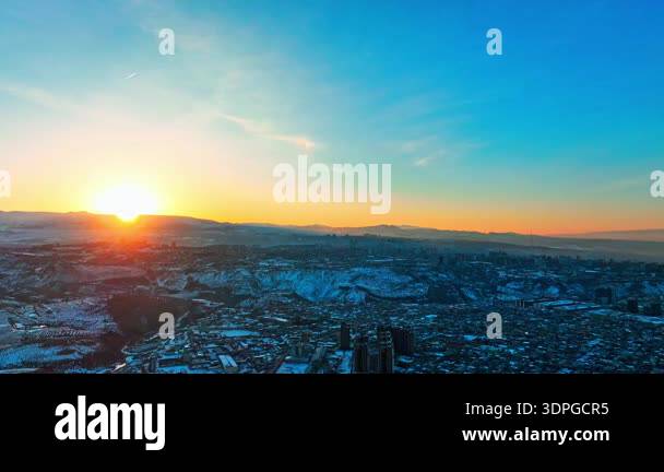 Aerial sunset view of Yerevan city covered in snow with Mount Ararat in ...