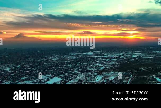 Aerial sunset view of Yerevan city covered in snow with Mount Ararat in ...