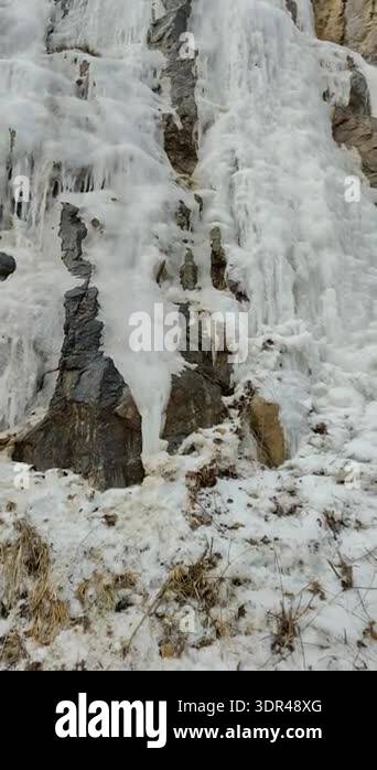 Frozen waterfall and icicles covering rocky cliff in Kadzielnia nature ...