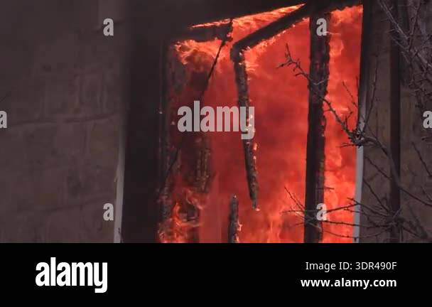 Close-up of a severe fire in a house. Red flames of fire burst out of ...