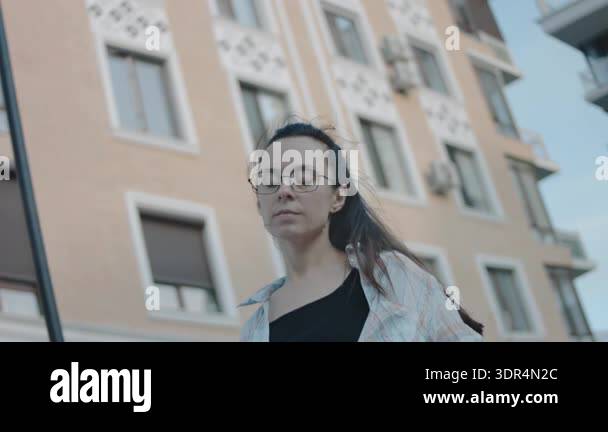 Close up portrait of a very serious woman standing alone in front of a ...
