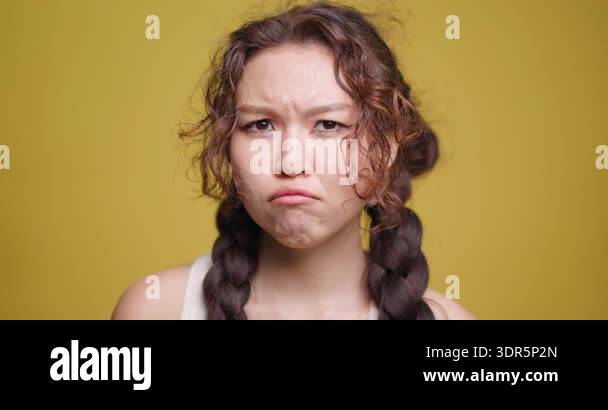 Close-up portrait of a young Kazakh woman with braided hair, expressing ...