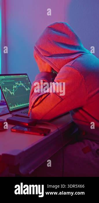 Hooded Person Slumped Over Trading Laptop, Neon Red And Blue Lighting ...