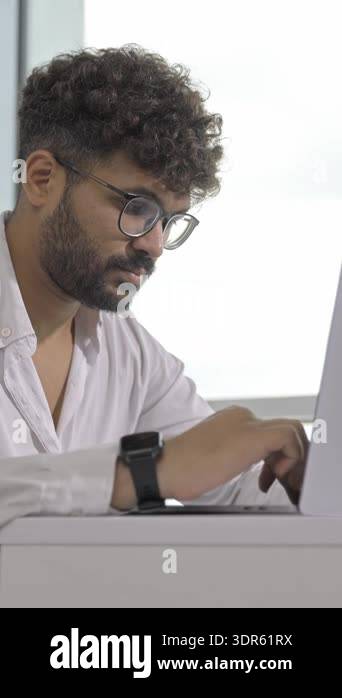 Concentrated young businessman developer or web designer wearing ...