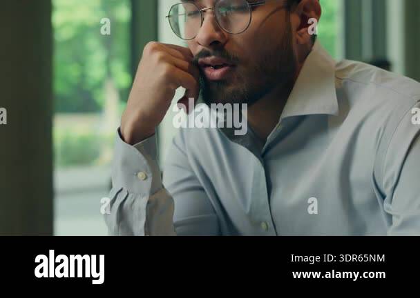 Close up yawning Indian business man drinking coffee for energy writing ...