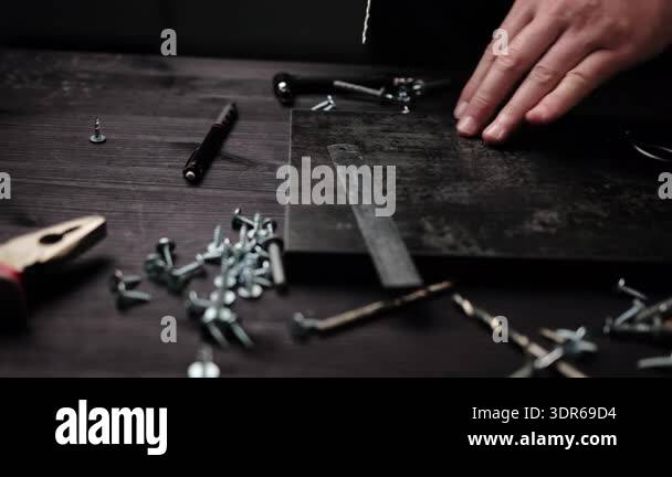 Carpenter Marking A Board For Drilling To Make Home Shelves From Black ...