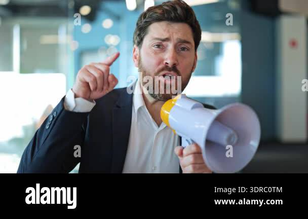 Businessman shouting loudly into megaphone, expressing intense anger ...