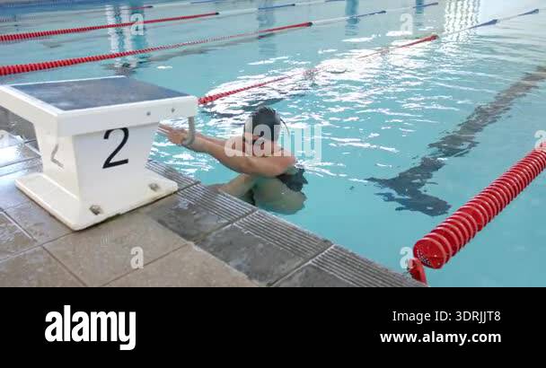 Swimmer gripping block 2 handles, pushing off wall in sports training ...