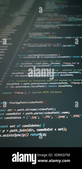 Colorful Javascript code scrolls vertically on a dark computer monitor ...