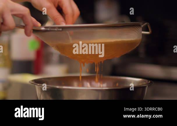 Sauce making. Puree food. Chef hand grinding hot mass in metal bowl ...
