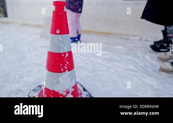 Red And White Ice Rink Training Cones On A Rink With People Skating In ...