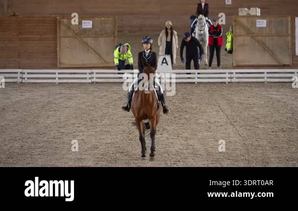 Female athlete riding horse during dressage training or competition in ...