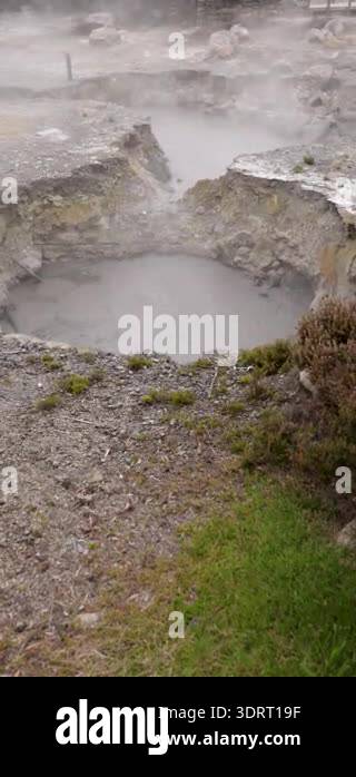 Volcanic pit with mud and boiling water with steam rising to the ...