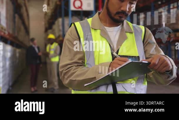 Warehouse worker writing clipboard and visualizing stock with charts ...