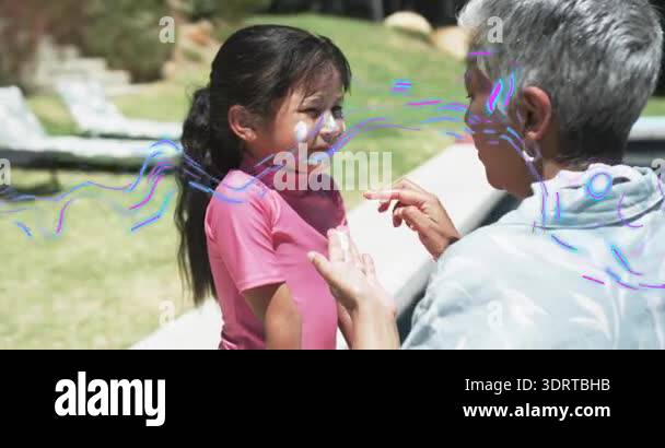 After dipping finger in sunscreen caregiver applying lotion rubbing ...