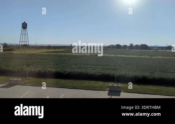 Static wide shot from near I-29 in Iowa shows a vast green farm field ...