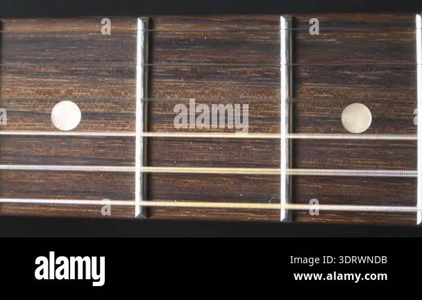 Close up of trembling guitar strings against fret. Chords being ...