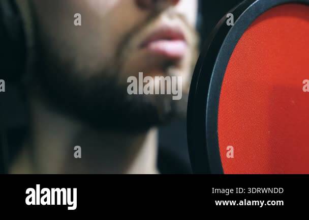 Unrecognizable male singer in headphones singing song at sound studio ...
