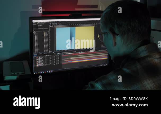 Video editor working on motion graphics project at workstation ...