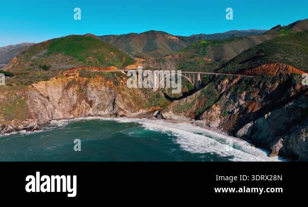 Bixby Creek Bridge aerial view with ocean waves and mountains. Historic ...