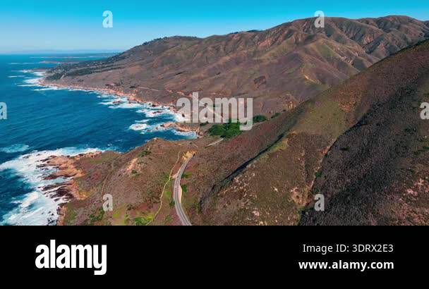 Wide aerial shot of Big Sur coastline and winding mountain road ...