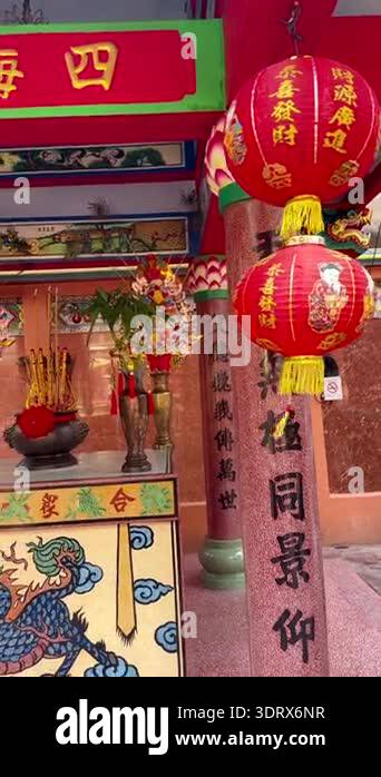 Traditional Chinese shrine altar with incense sticks, offerings and red ...