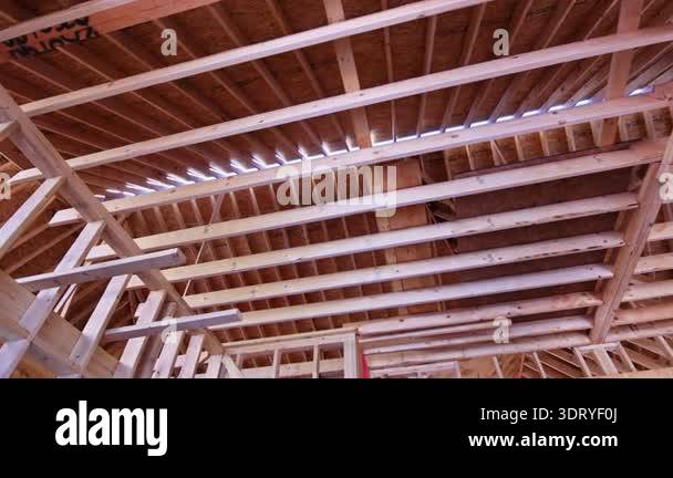 Wooden beams trusses create strong roof in building under construction ...