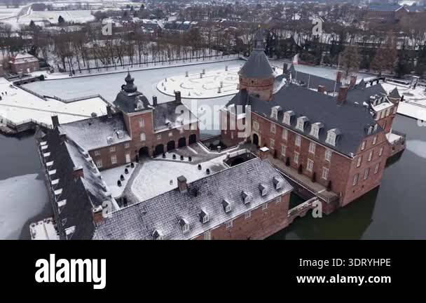 Aerial winter view of a red brick castle with steep slate roofs, ornate ...