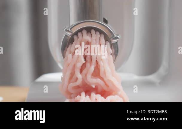 Electric meat grinder produces fresh minced meat from raw poultry ...