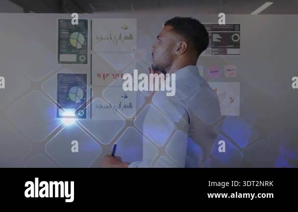 Businessman holding marker scanning charts, overlay graphics ...