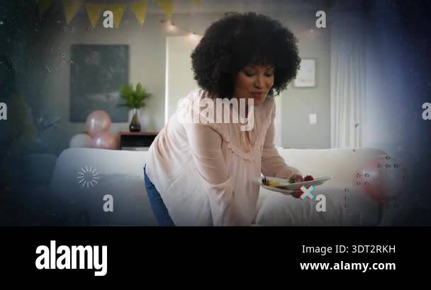 Woman entering room carrying dessert plate while friends arranging cake ...