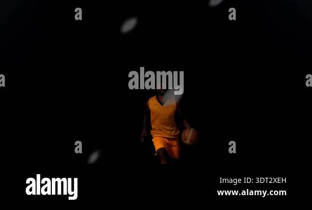 Athlete emerging from shadow dribbling past digital map before leaping ...