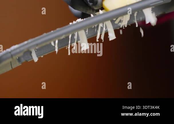 Gloved hands grating cheese over plate closeup, black nitrile gloves ...