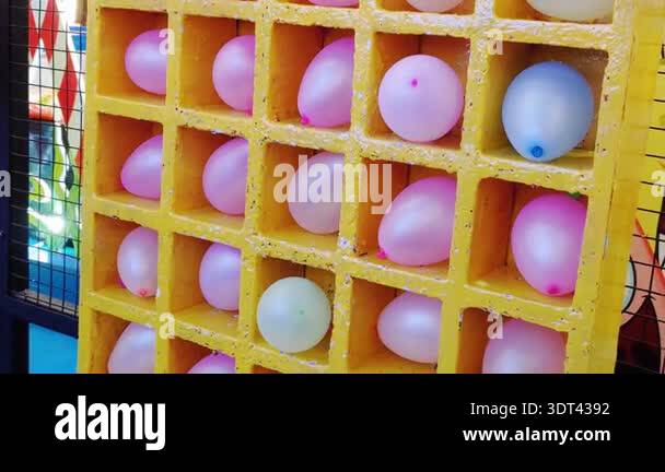 A classic carnival game featuring small balls inside a box targeted by ...