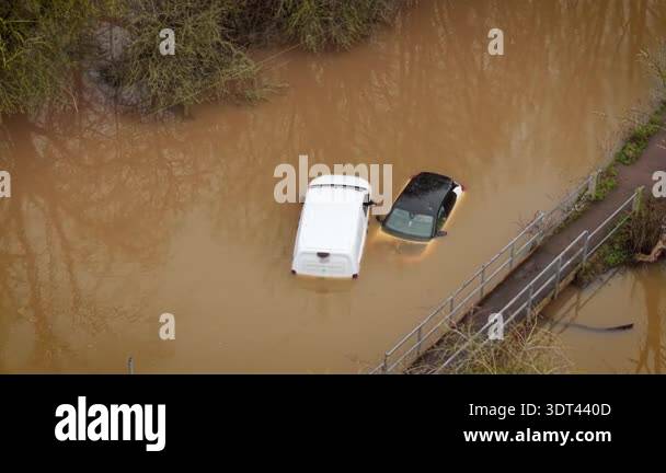 Aerial drone view over flooded road with cars sinking in muddy river ...