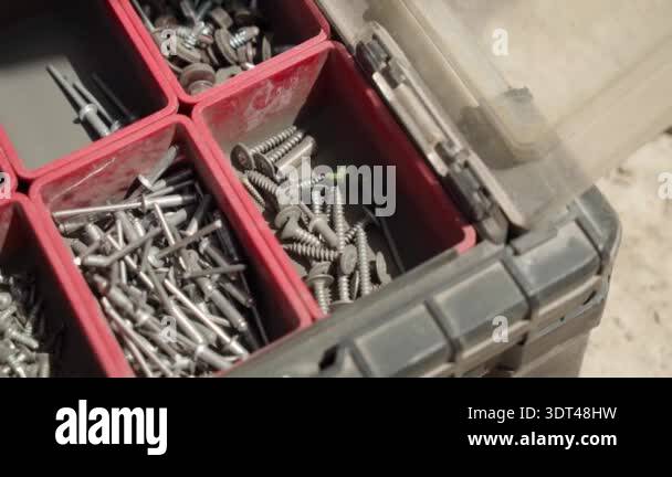 A close-up view of various metal fasteners, including rivets and screws ...